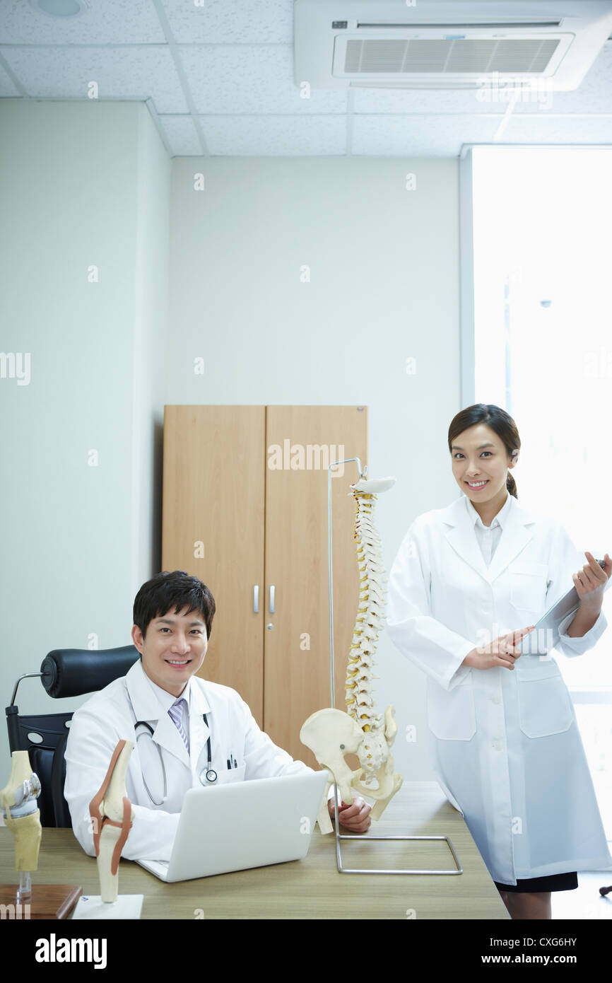 A female surgeon standing next to a male surgeon's office desk Stock ...