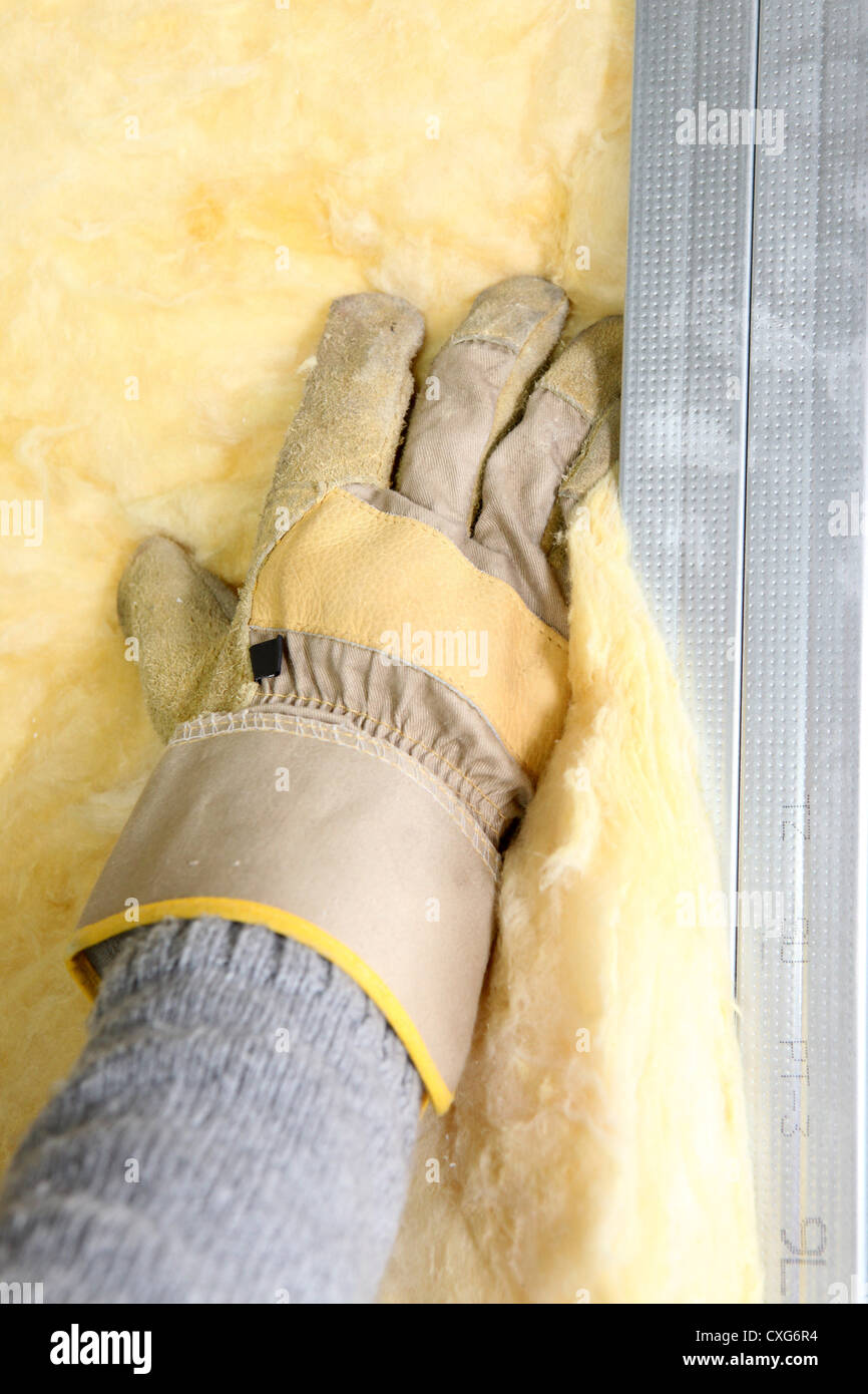 Worker installing insulation Stock Photo - Alamy