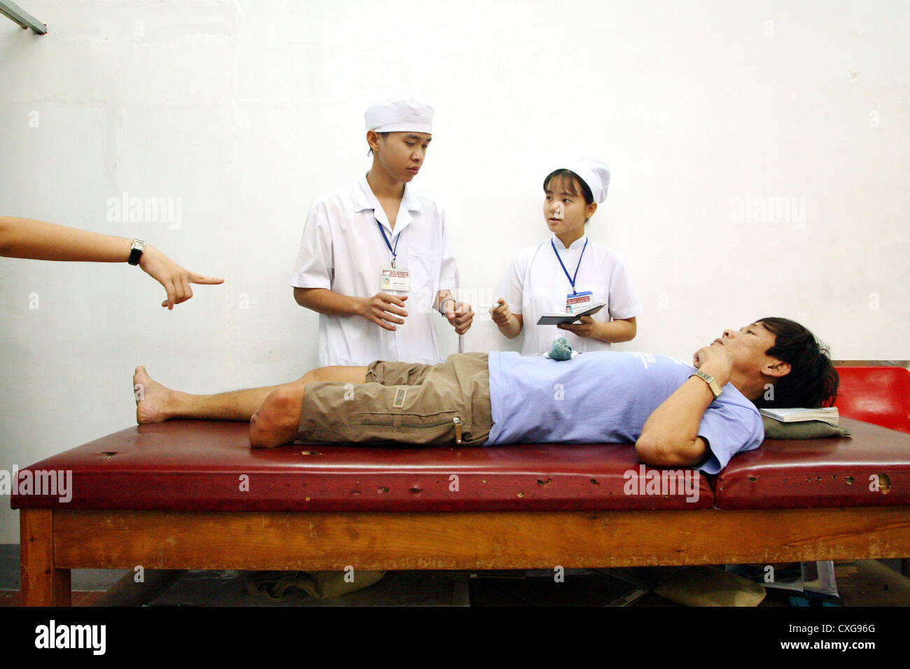 Students survey a leg amputee Orthopaedizentrum Saigon Stock Photo - Alamy