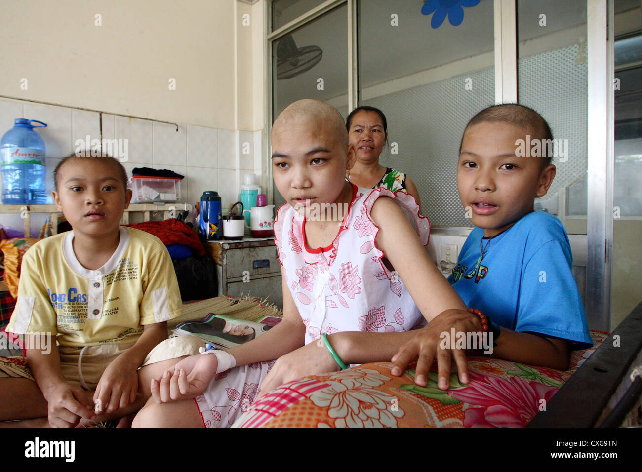 In a cancer ward of a hospital cancer-stricken children sit on a bed ...