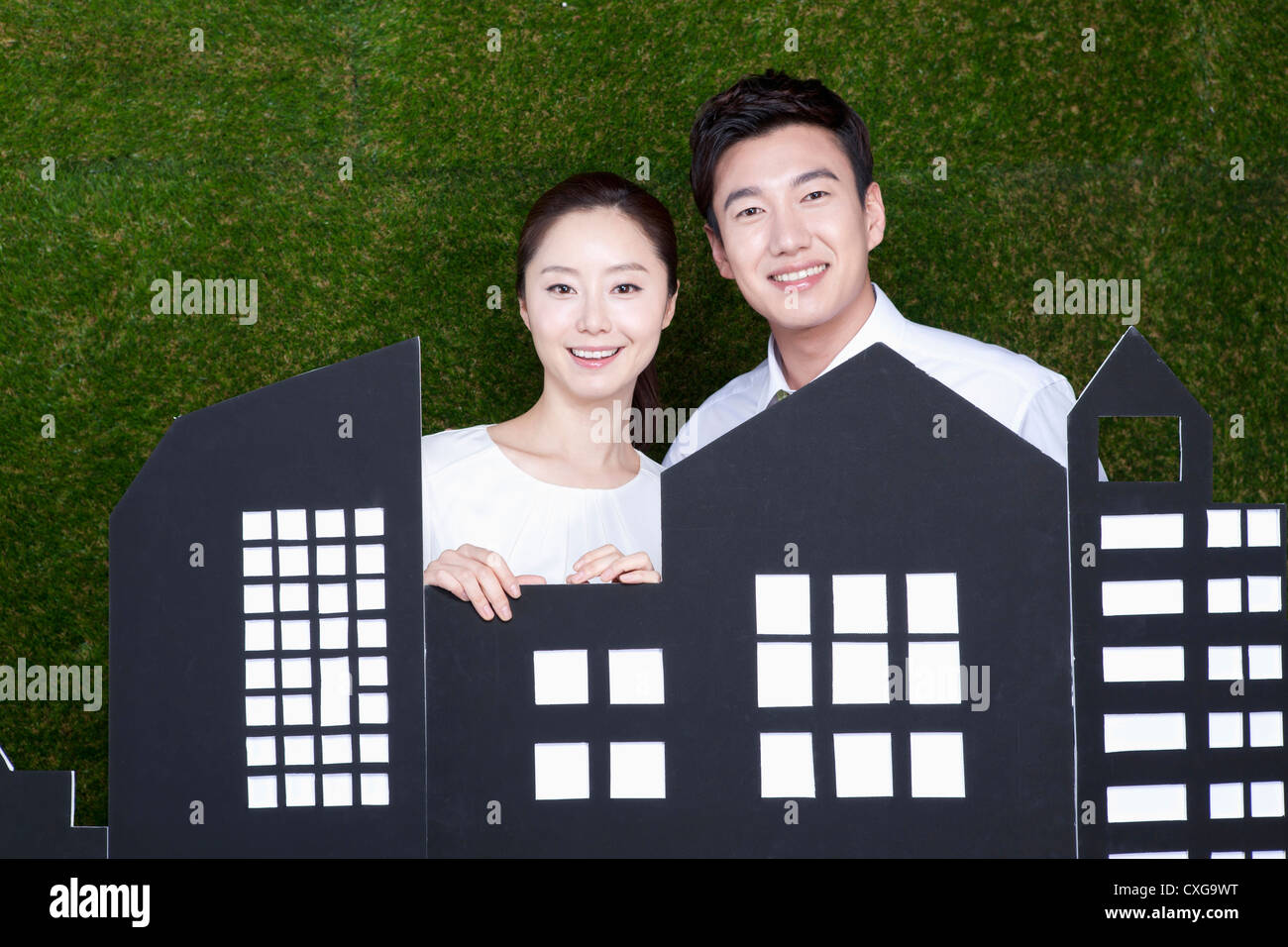 a couple standing behind the building model Stock Photo - Alamy