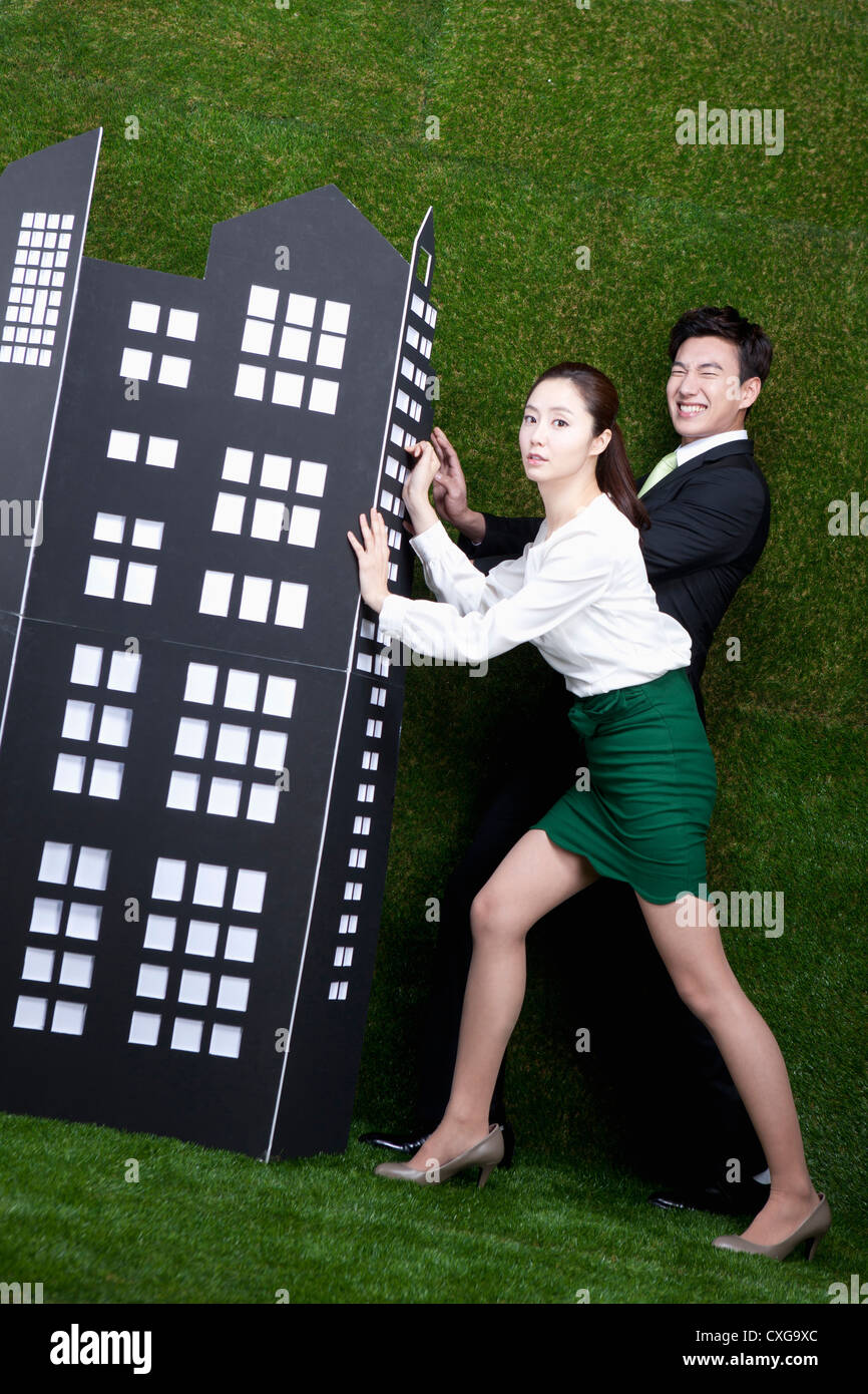 a couple pushing the building model together Stock Photo - Alamy