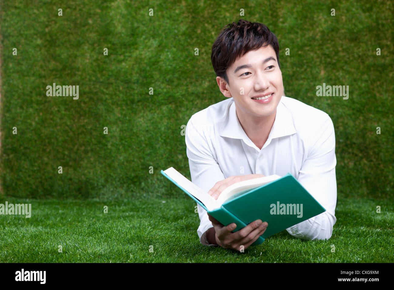 man lying face and reading a book Stock Photo - Alamy