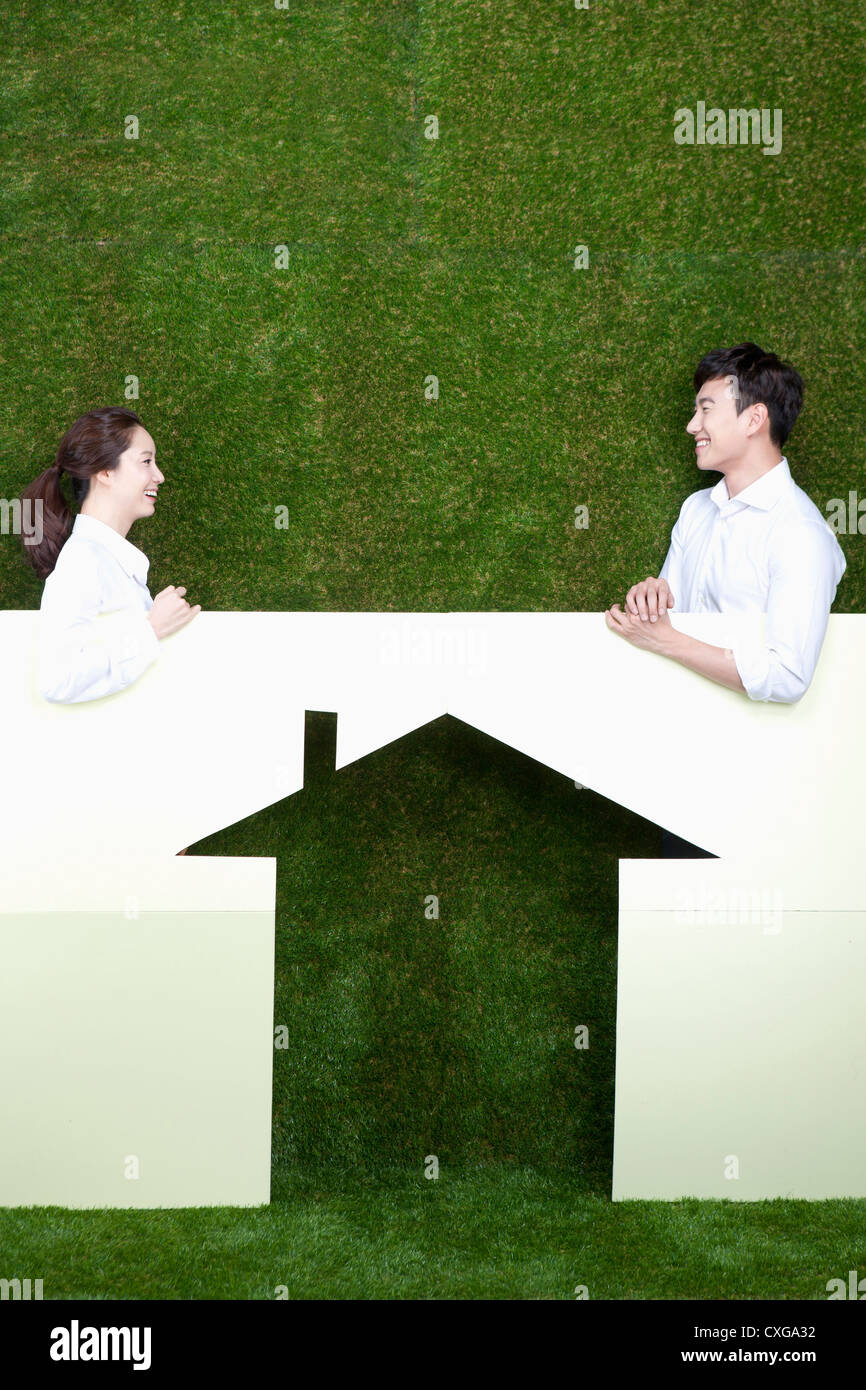 a couple standing behind the paper house Stock Photo - Alamy