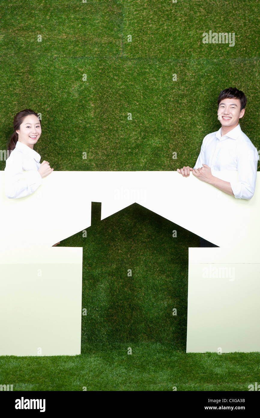 a couple standing behind the paper house Stock Photo - Alamy