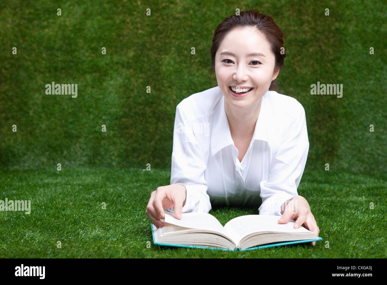 woman lying face and reading a book Stock Photo - Alamy