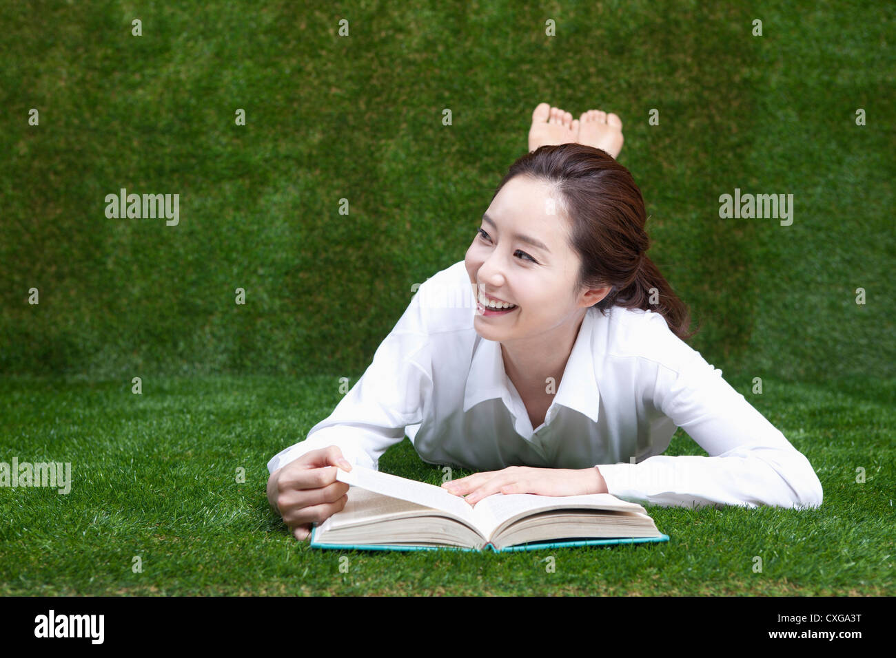 woman lying face and reading a book Stock Photo - Alamy