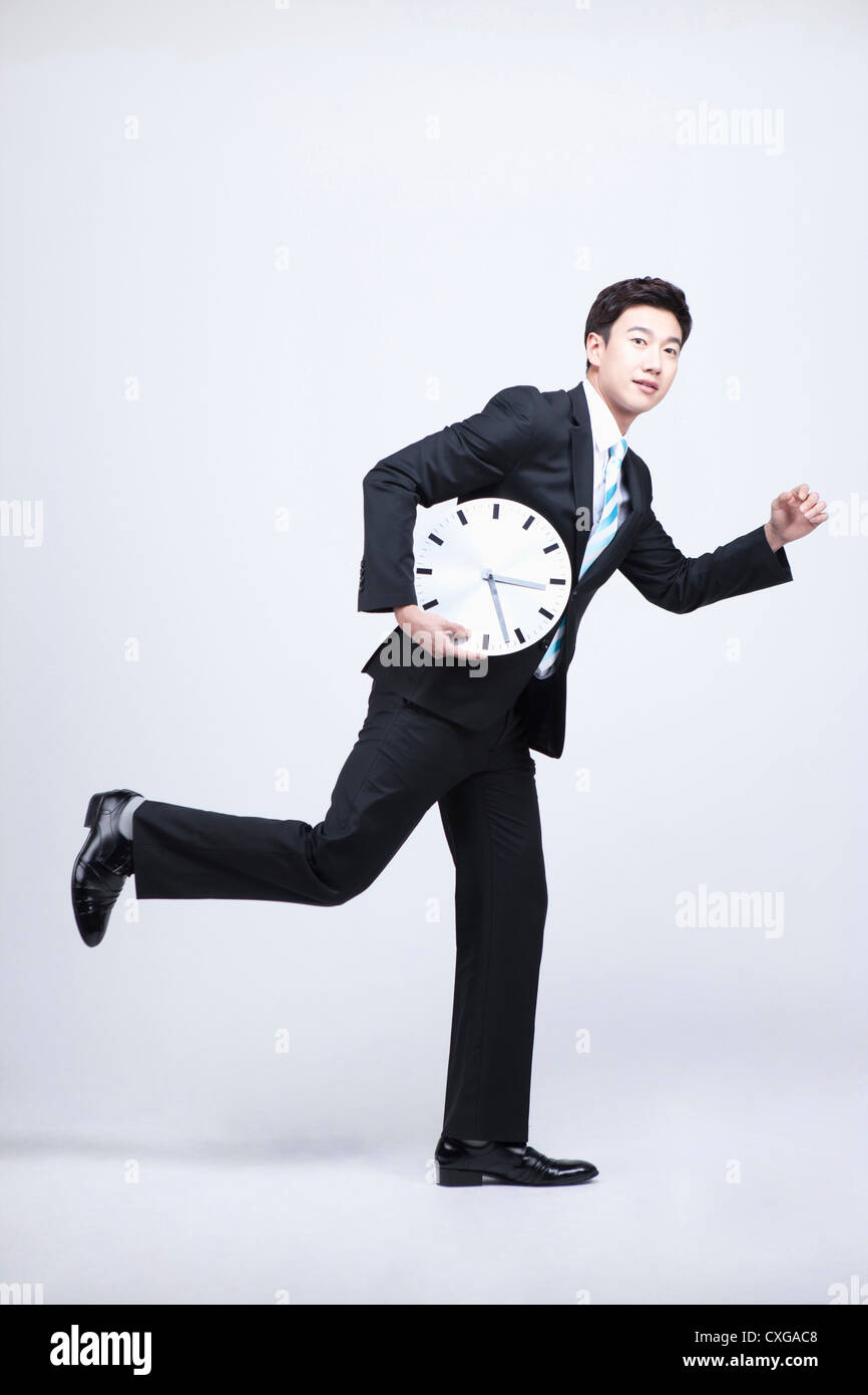 man carrying a clock and running Stock Photo - Alamy