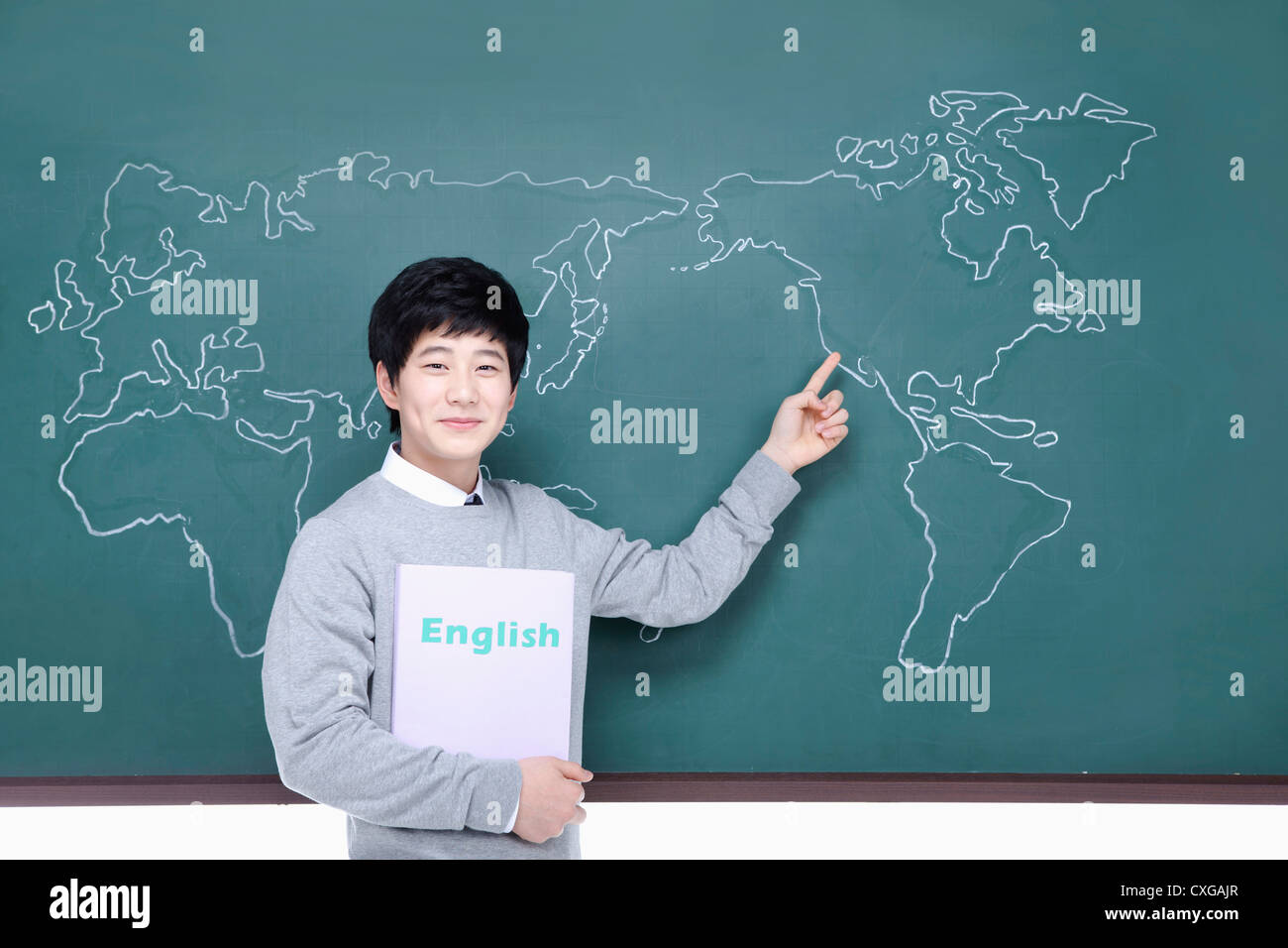 schoolboy pointing out one place in the world map in the blackboard ...
