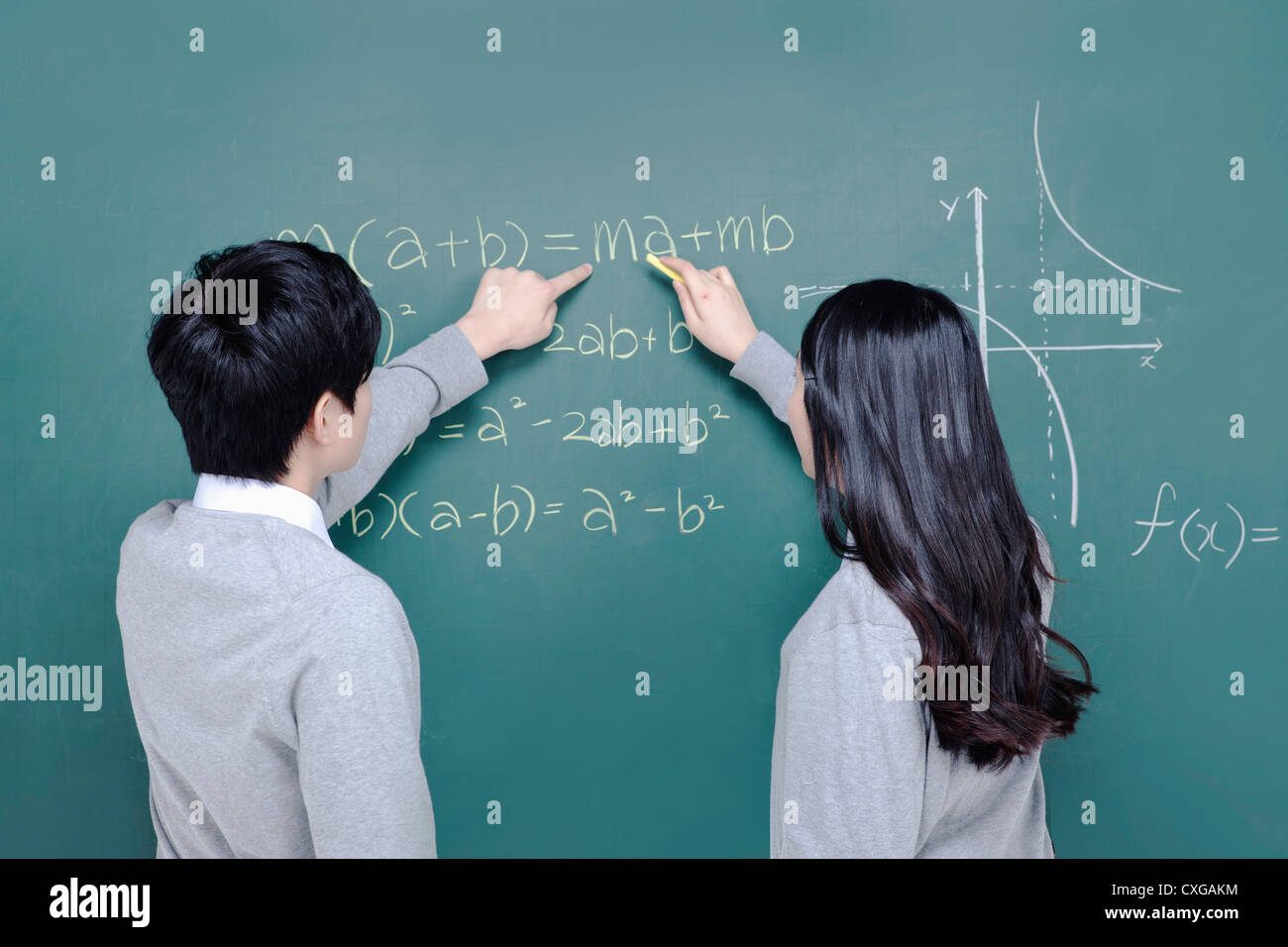 a couple of students solving a problem on the blackboard Stock Photo ...