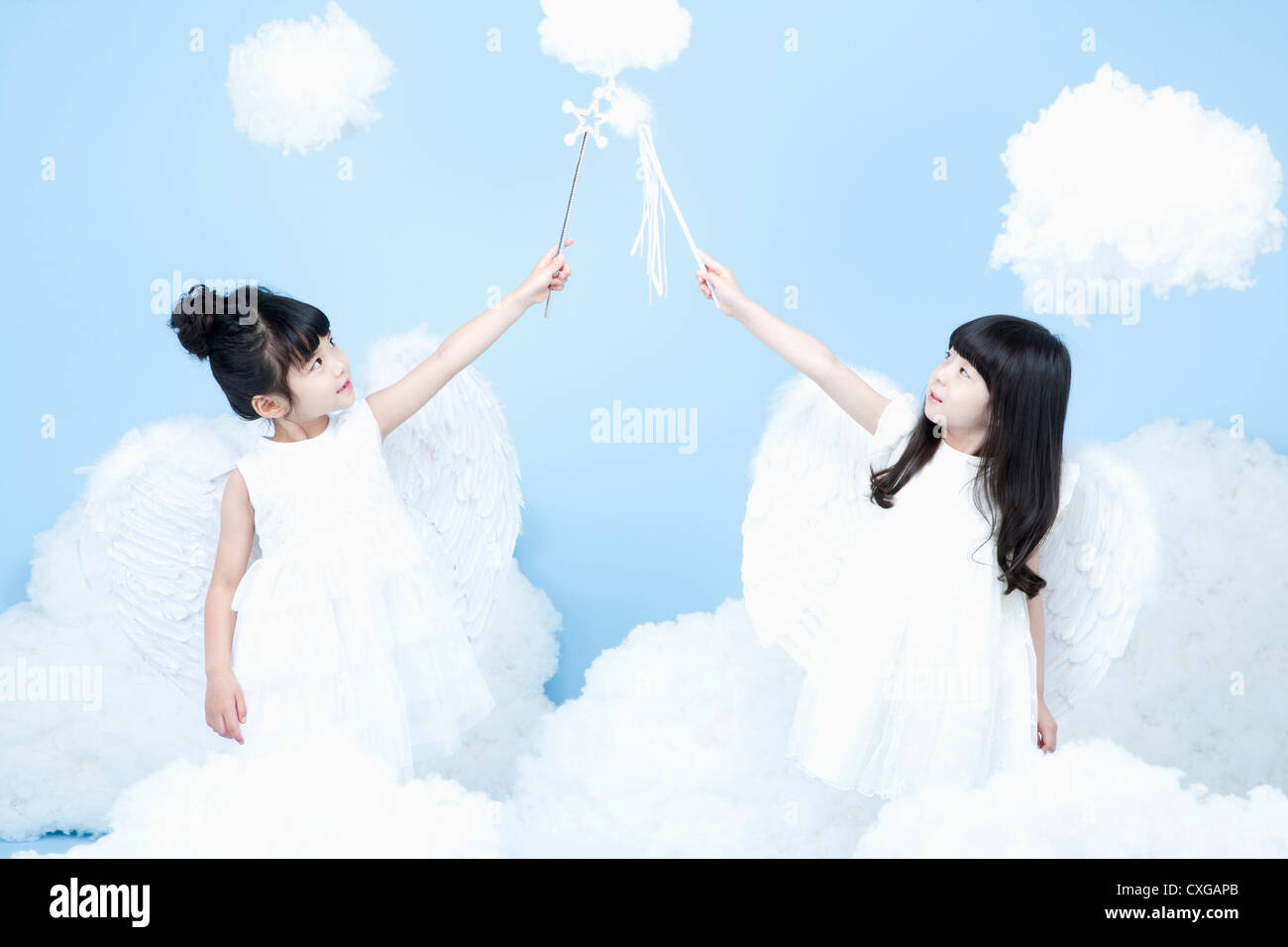 two little girls with looks of angels on the clouds Stock Photo - Alamy