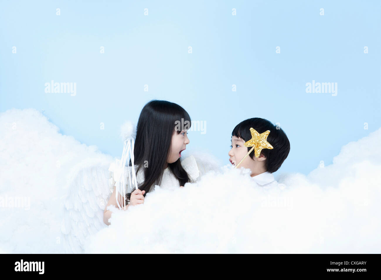 two kids with looks of angels on the clouds Stock Photo - Alamy