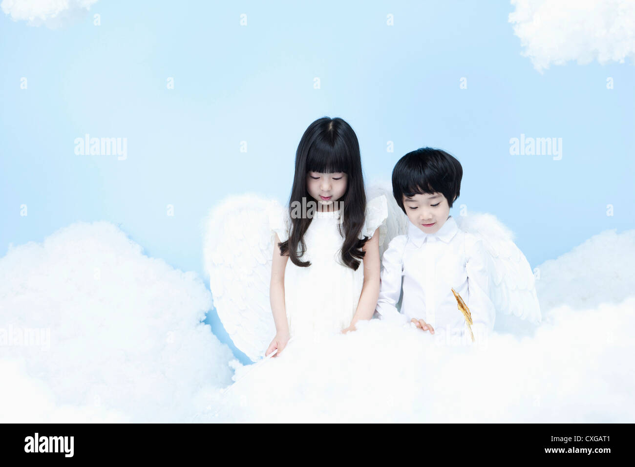 two kids with looks of angels on the clouds Stock Photo - Alamy
