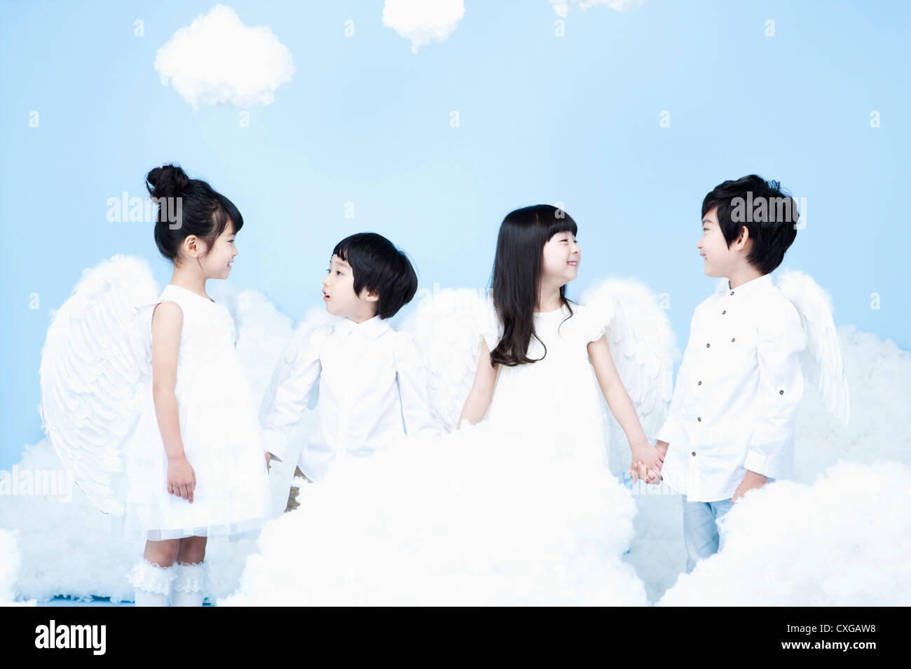 four kids with looks of angels on the clouds Stock Photo - Alamy