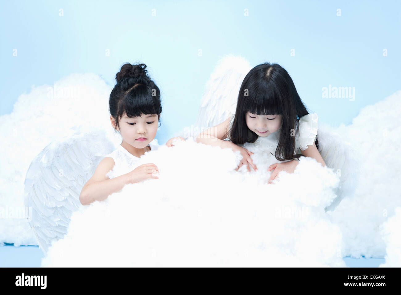 two little girls with looks of angels on the clouds Stock Photo - Alamy