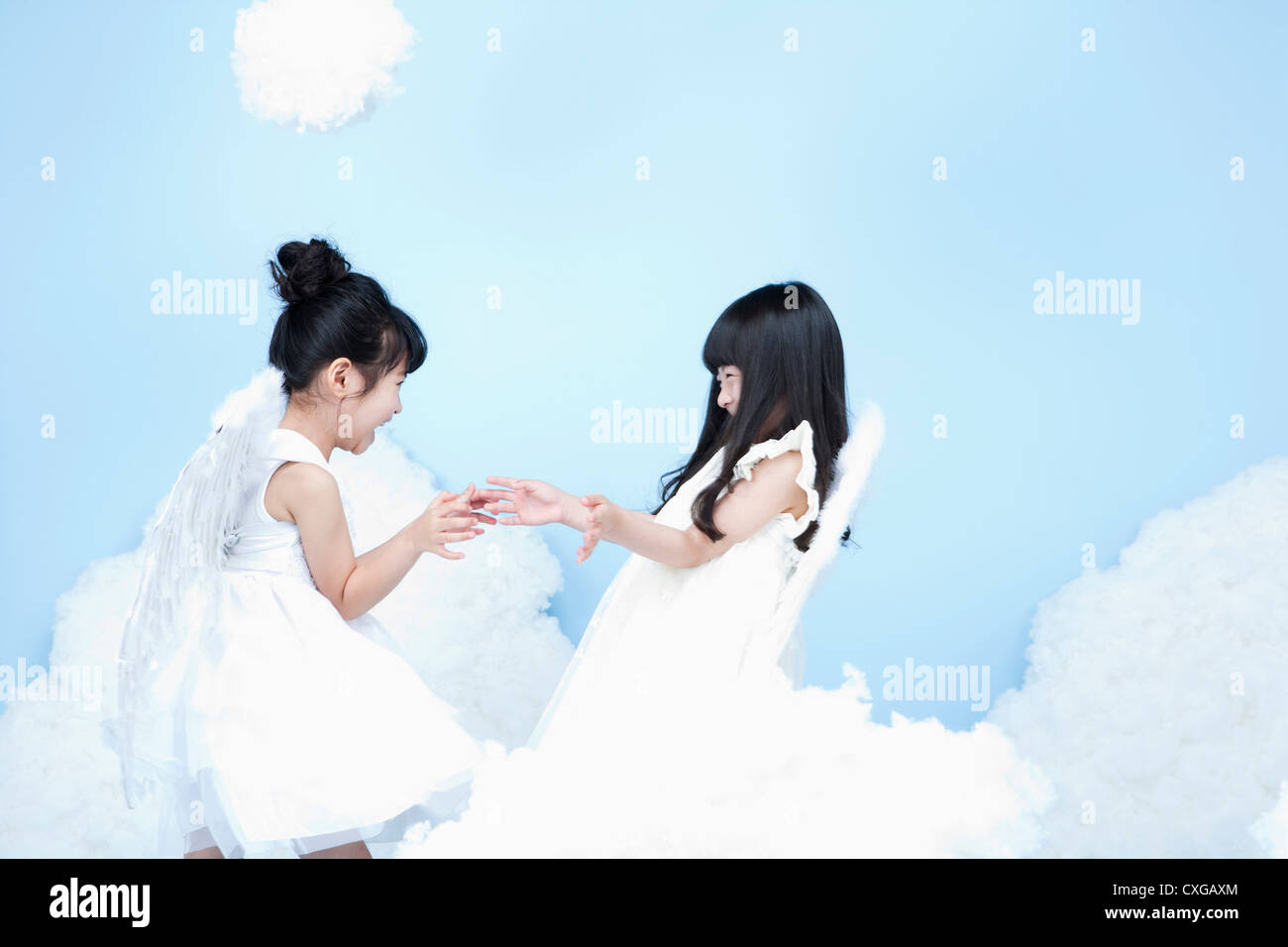 two little girls with looks of angels on the clouds Stock Photo - Alamy