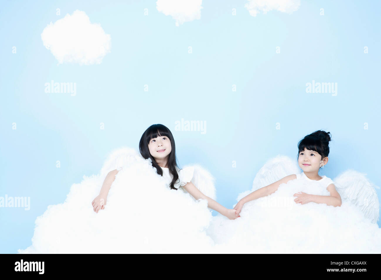 two little girls with looks of angels on the clouds Stock Photo - Alamy