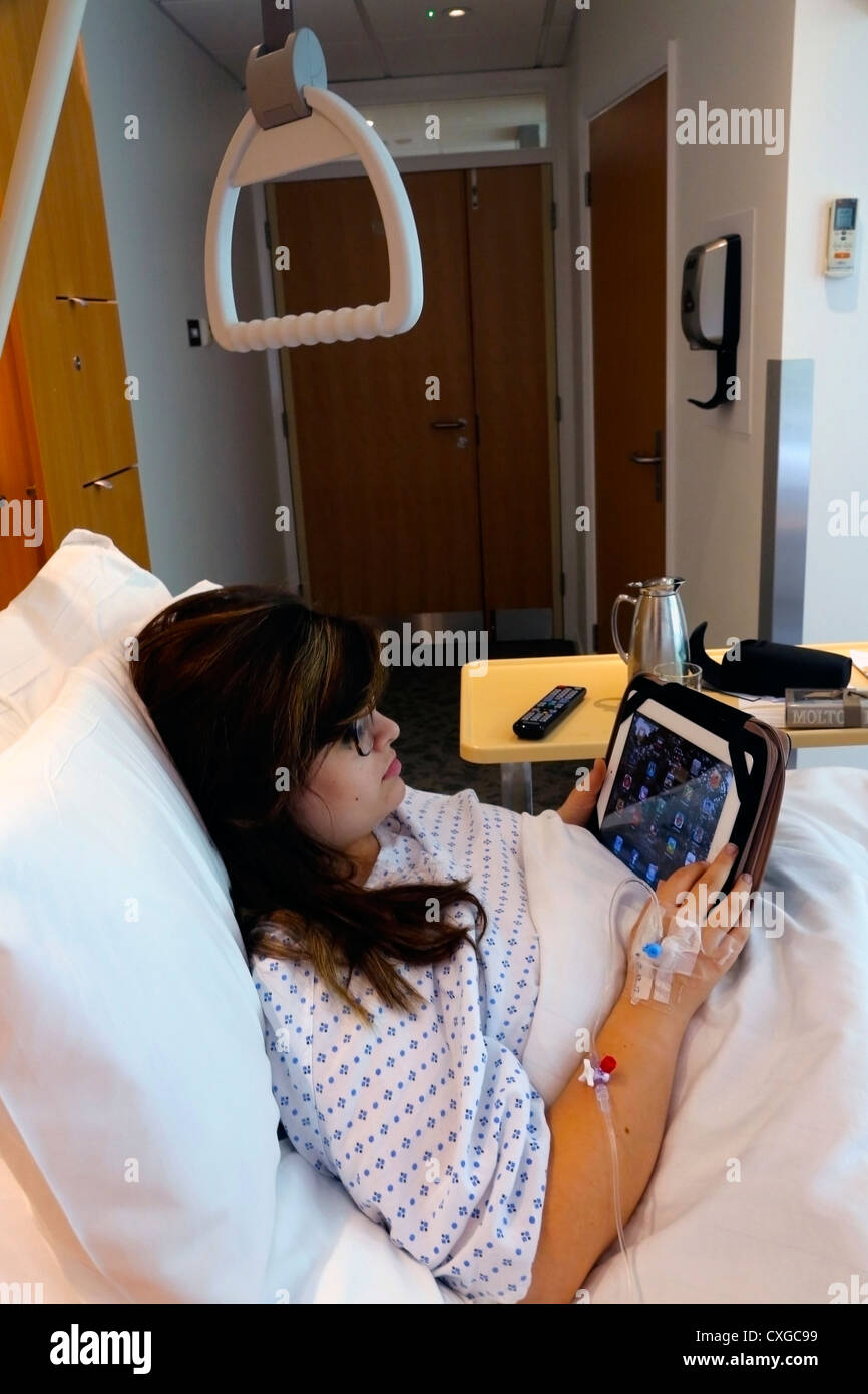 Patient With Cannula In Hospital Bed Working On iPad Ashtead Surrey ...