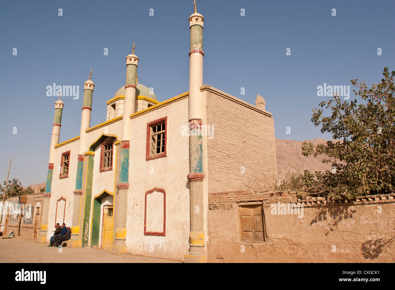 Uighur men sit outside a mosque in a village at the foot of the Flaming ...