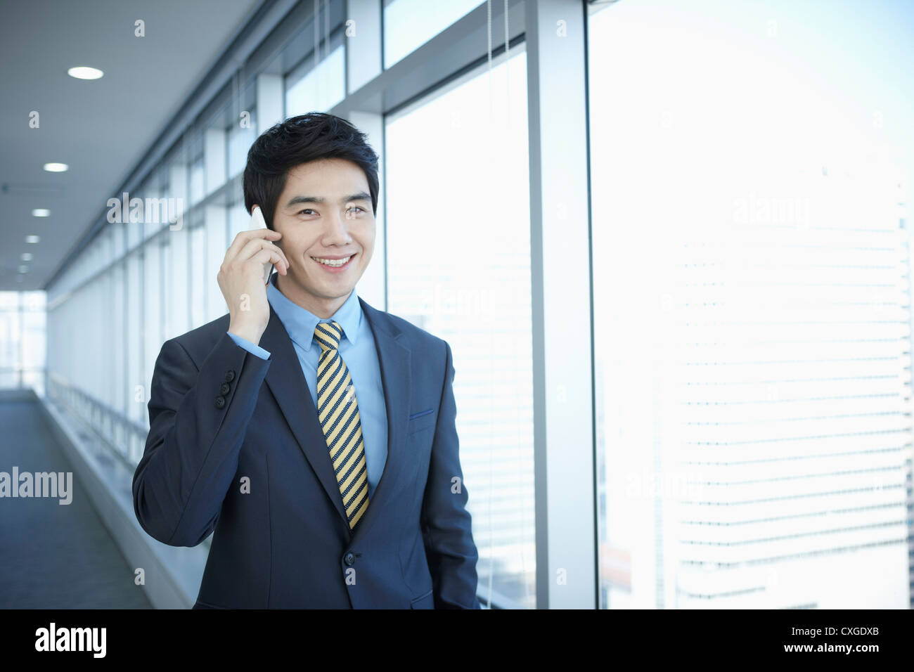 A businessman smiling while answering a phone Stock Photo - Alamy
