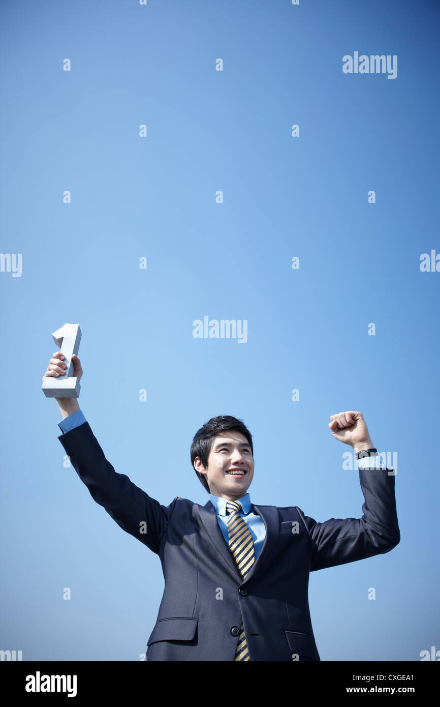 A businessman holding number one sign in his hand Stock Photo - Alamy
