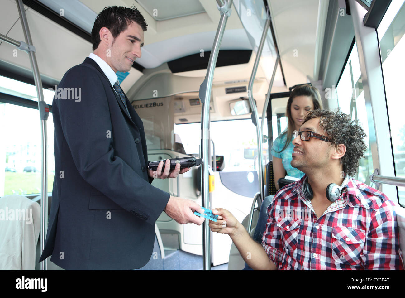 A young controller controlling passengers in a bus Stock Photo - Alamy
