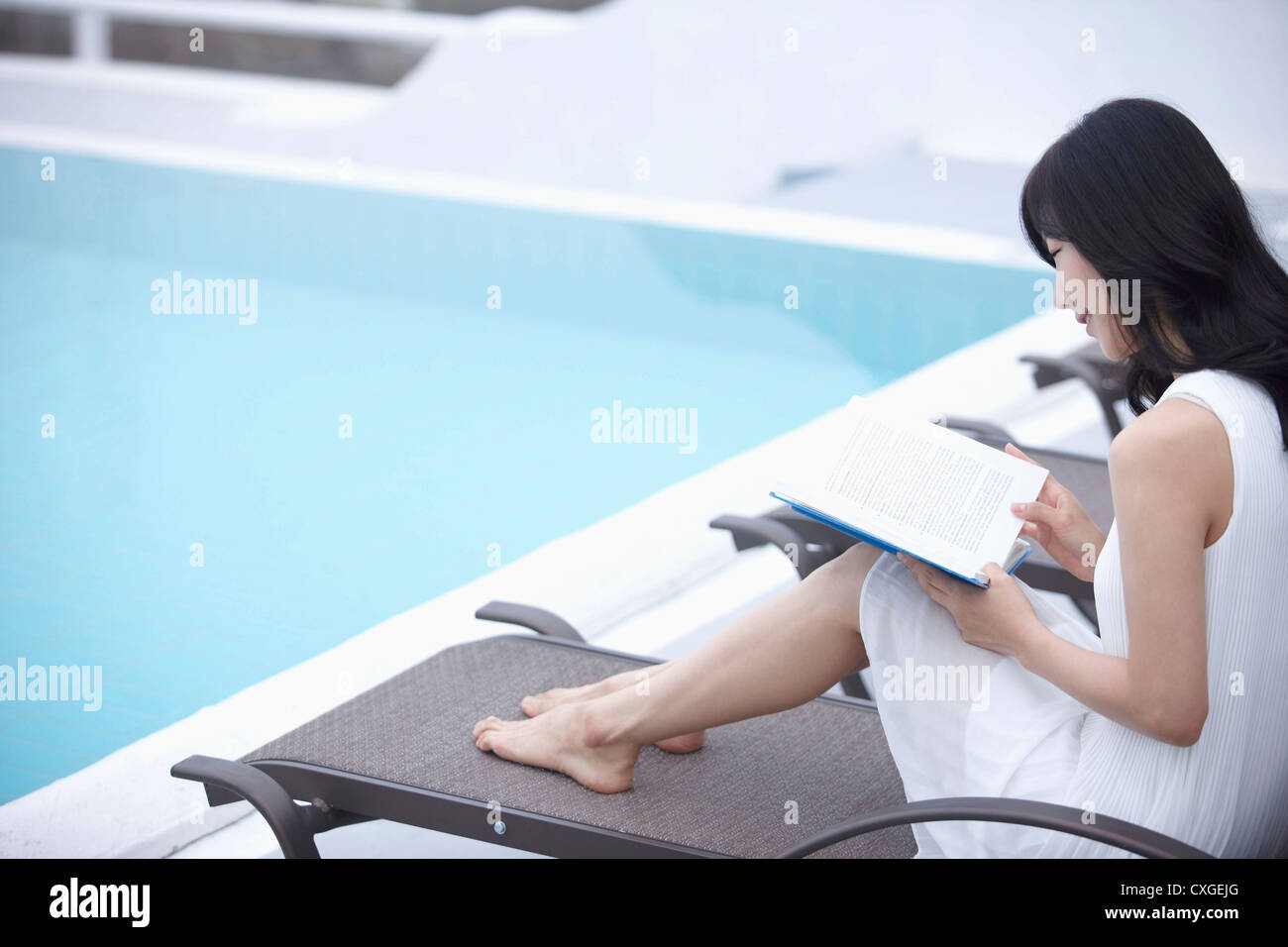 Reading book by the swimming pool hi-res stock photography and images ...