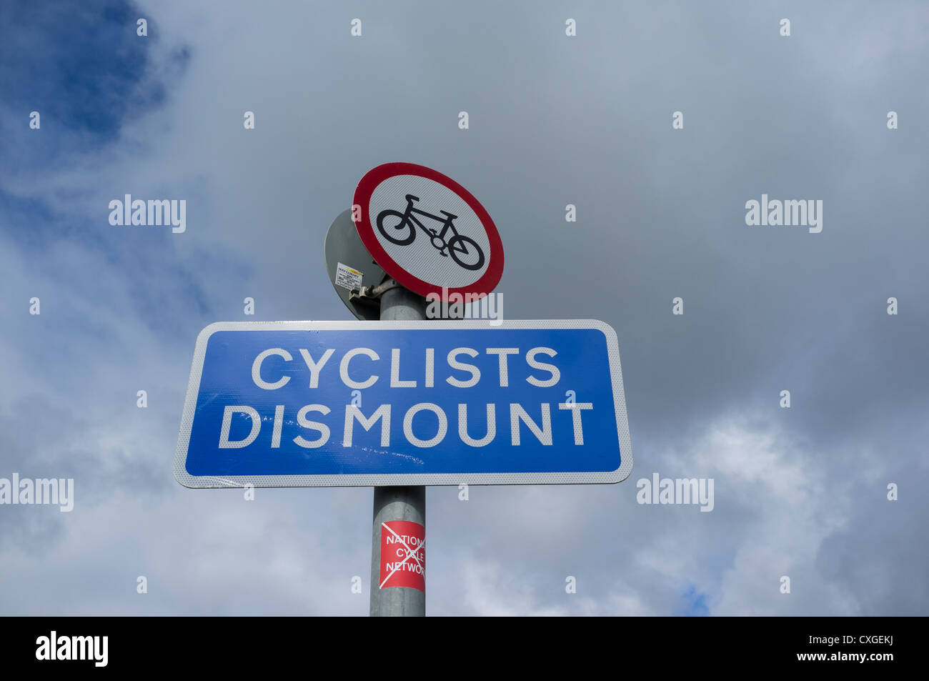 Cyclists Dismount sign against the sky Stock Photo - Alamy