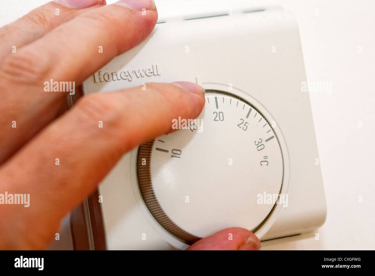 adjusting a room thermostat on the central heating Stock Photo - Alamy