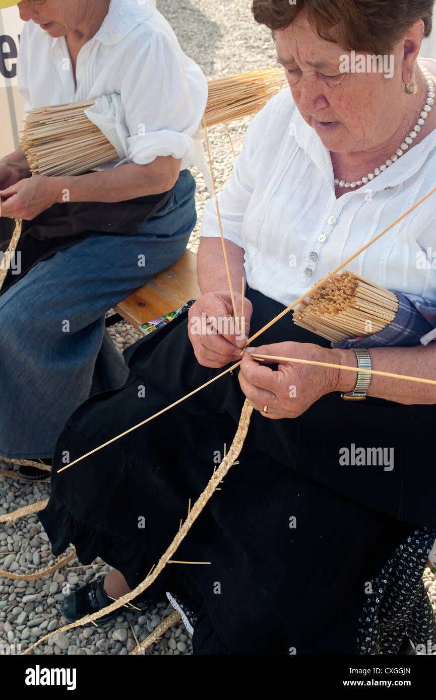Women working straw hats at the farmers' market. Rome, Italy Stock ...