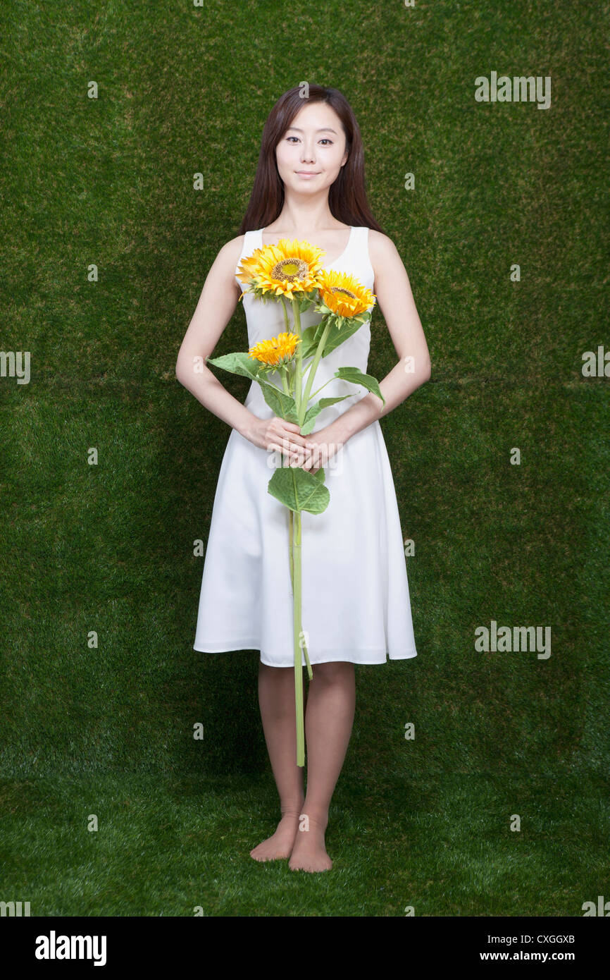 woman holding sunflower in her bare feet Stock Photo - Alamy