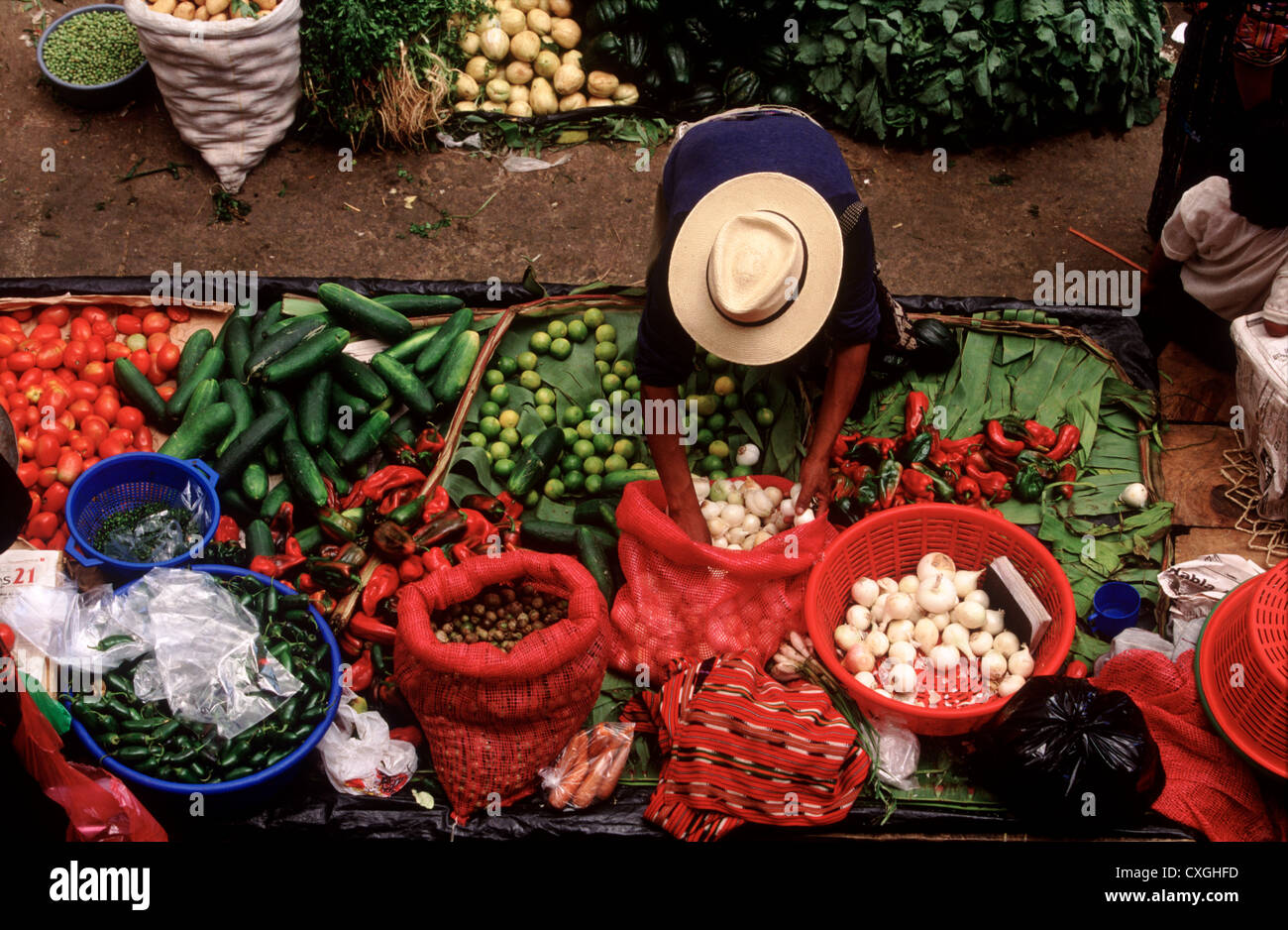 Indian man bending over sack at his stall in indoor market Stock Photo ...