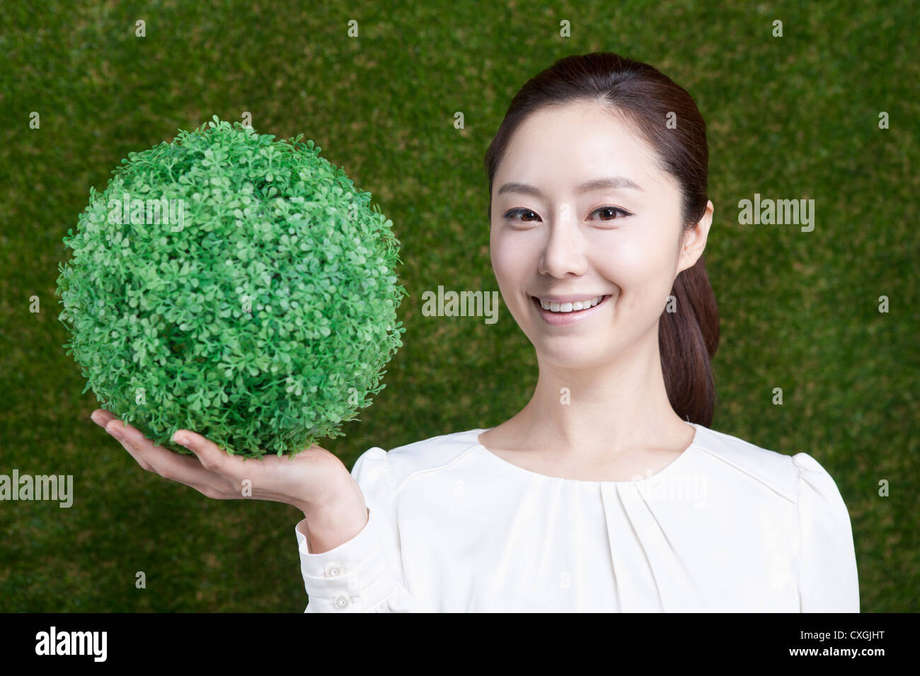 woman holding a sphere covered with grass Stock Photo - Alamy