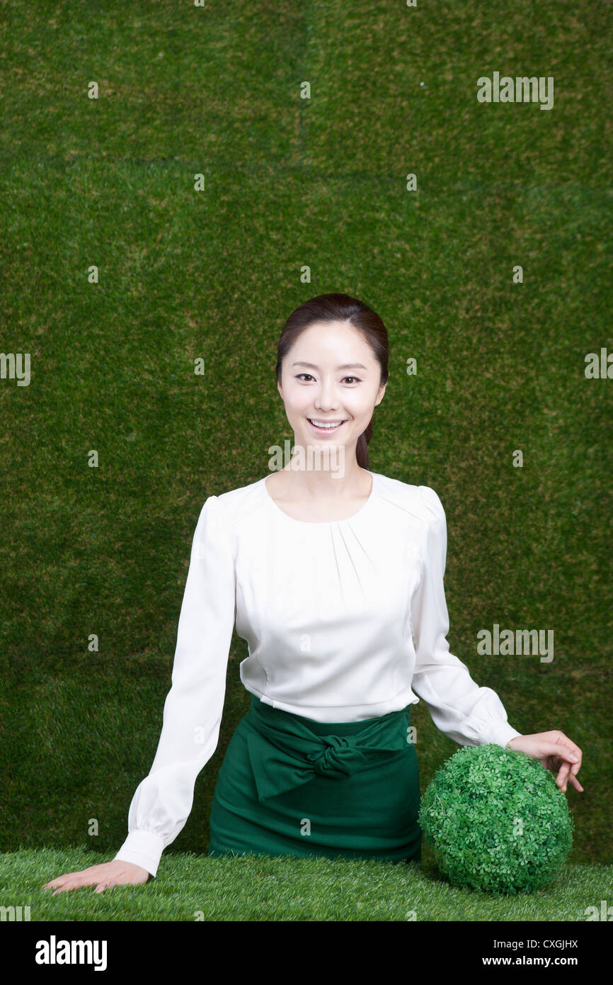 woman holding a sphere covered with grass Stock Photo - Alamy