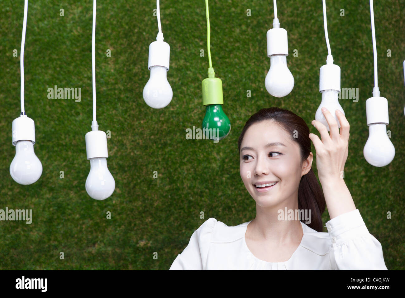 woman holding one the bulbs hanging on the ceiling Stock Photo - Alamy