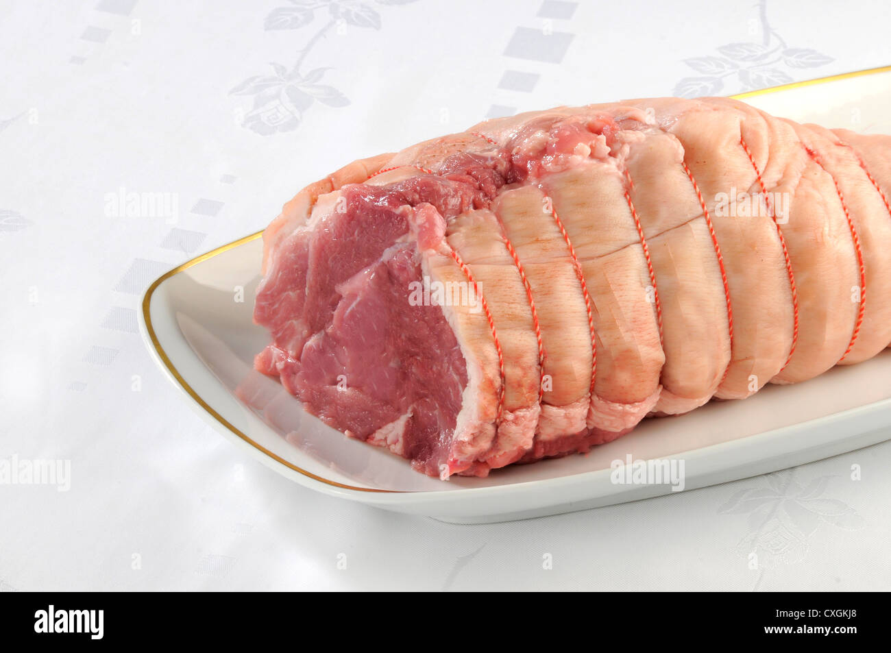 A boneless hand of pork joint on a white platter and tablecloth Stock ...