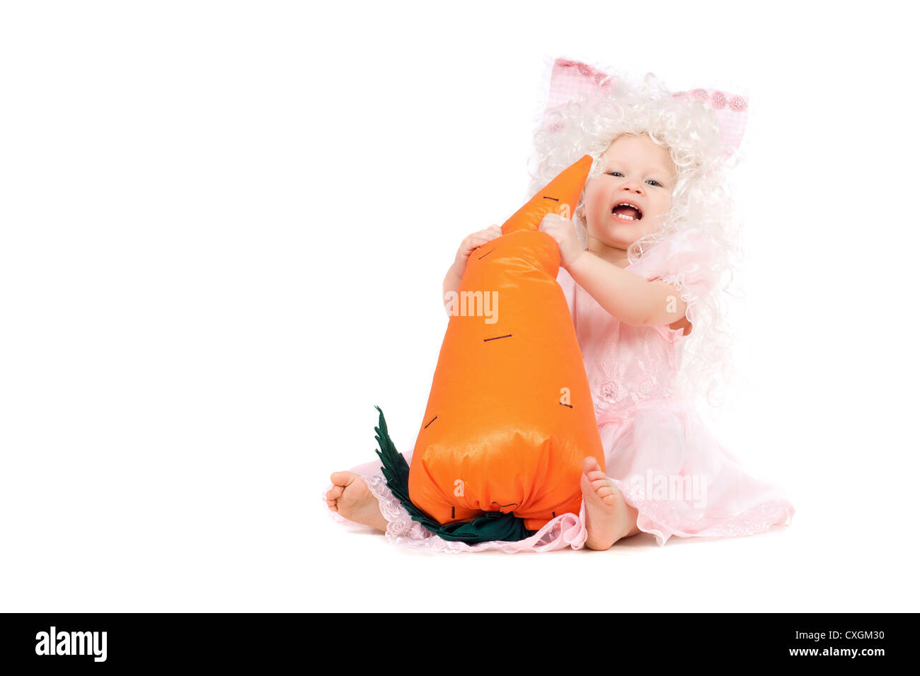 Happy baby girl plays with a carrot Stock Photo - Alamy