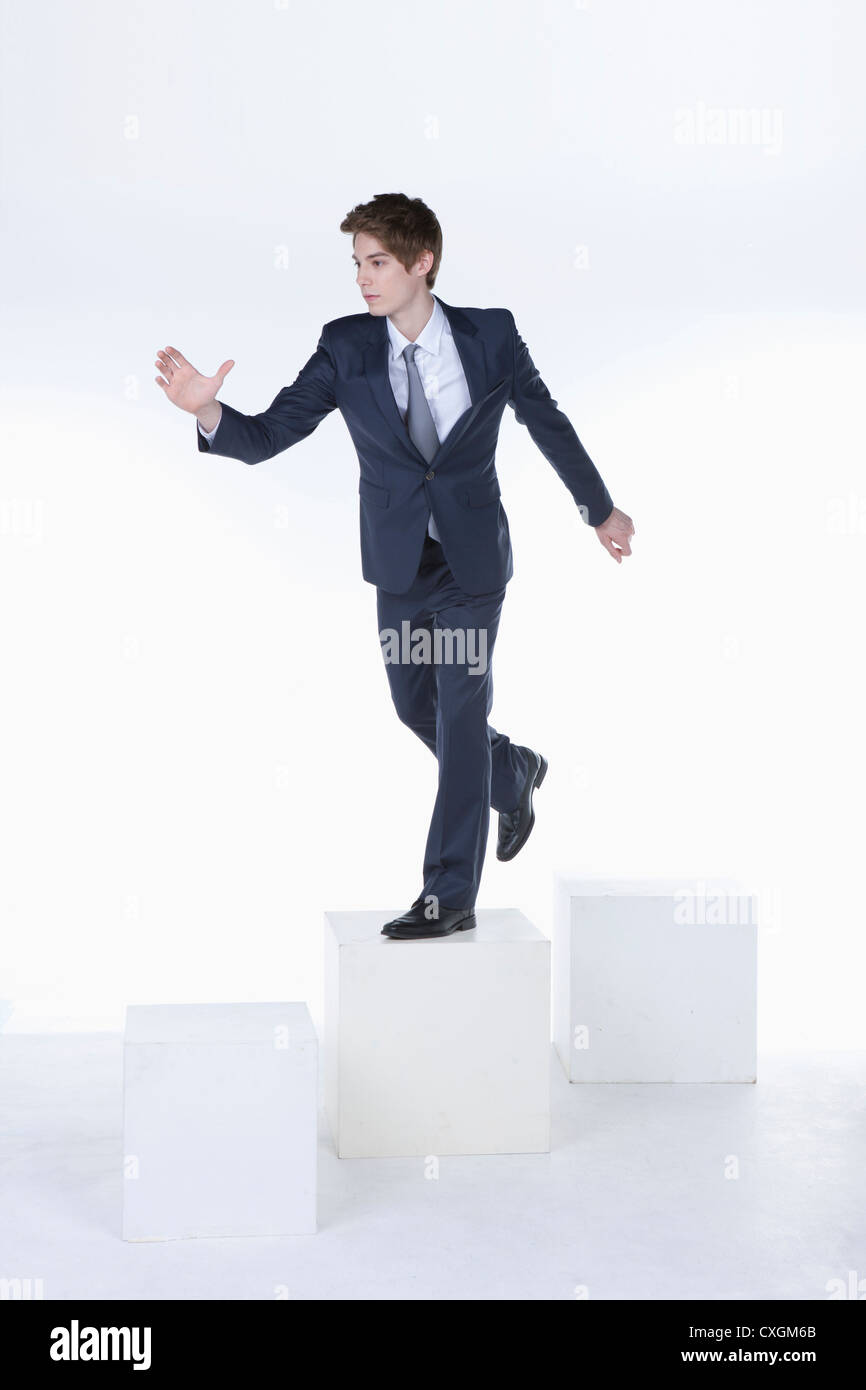 businessman standing on the box and reaching out his hand Stock Photo ...
