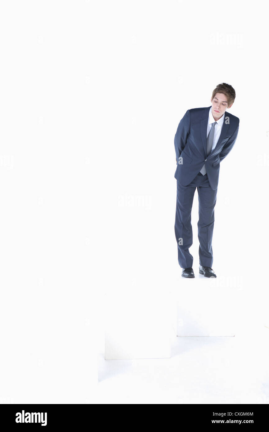 businessman standing on the box and bending his body Stock Photo - Alamy