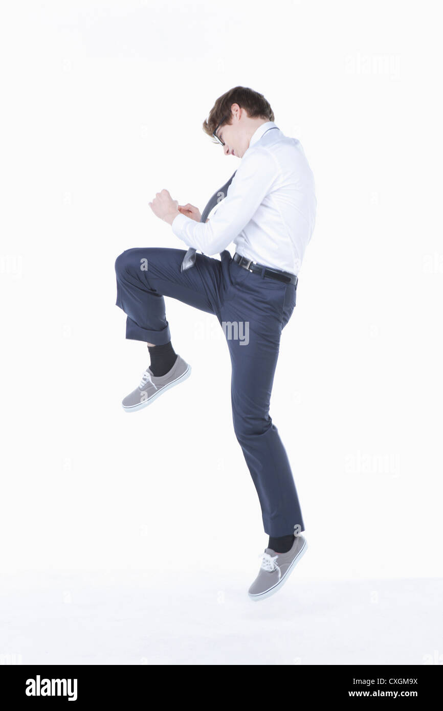 businessman bending his knee to kick Stock Photo - Alamy