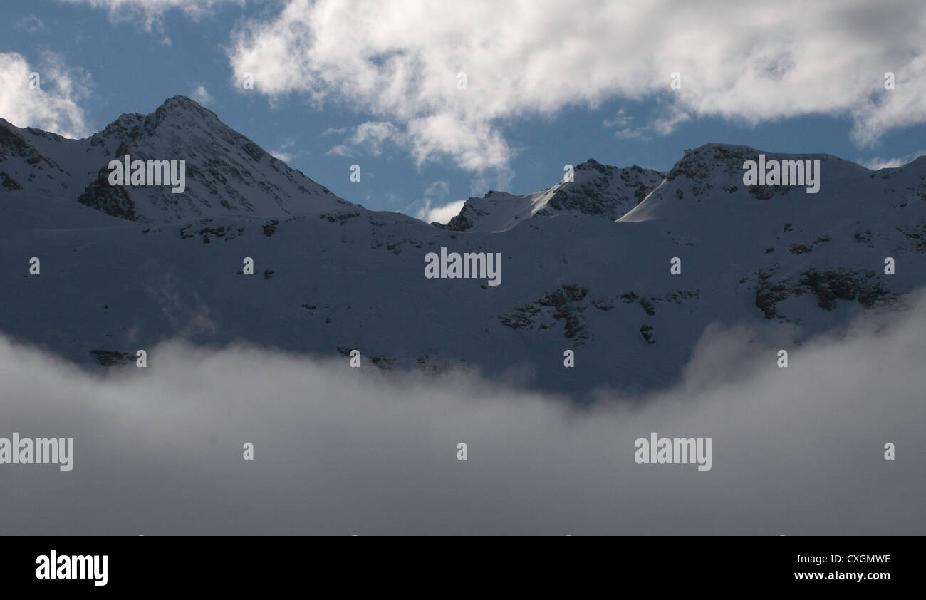 snow covered mountains in shadow with clouds Stock Photo - Alamy