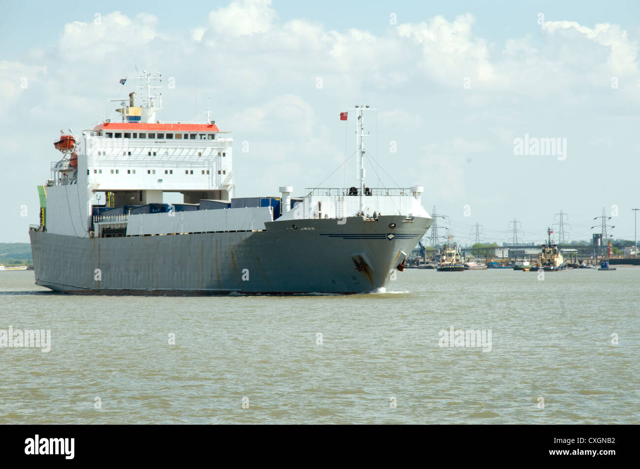 Large freighter sailing to dock with tugs in background Stock Photo - Alamy