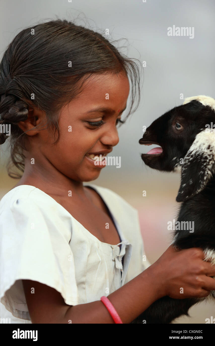Indian school girl playing with her pet goat Andhra Pradesh South India ...