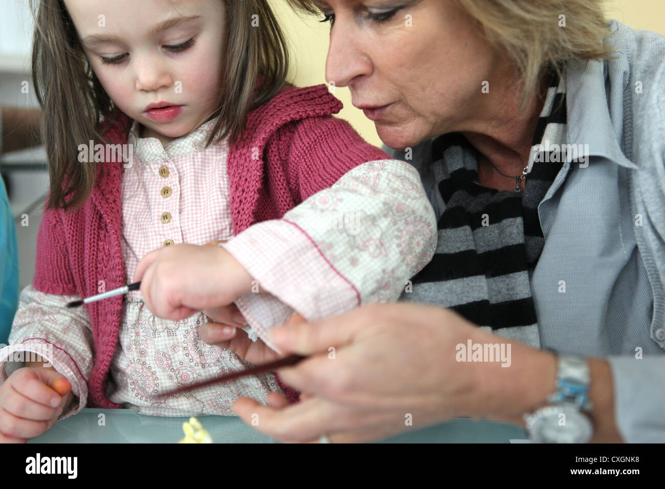 Mother repairing daughter's sleeve Stock Photo - Alamy