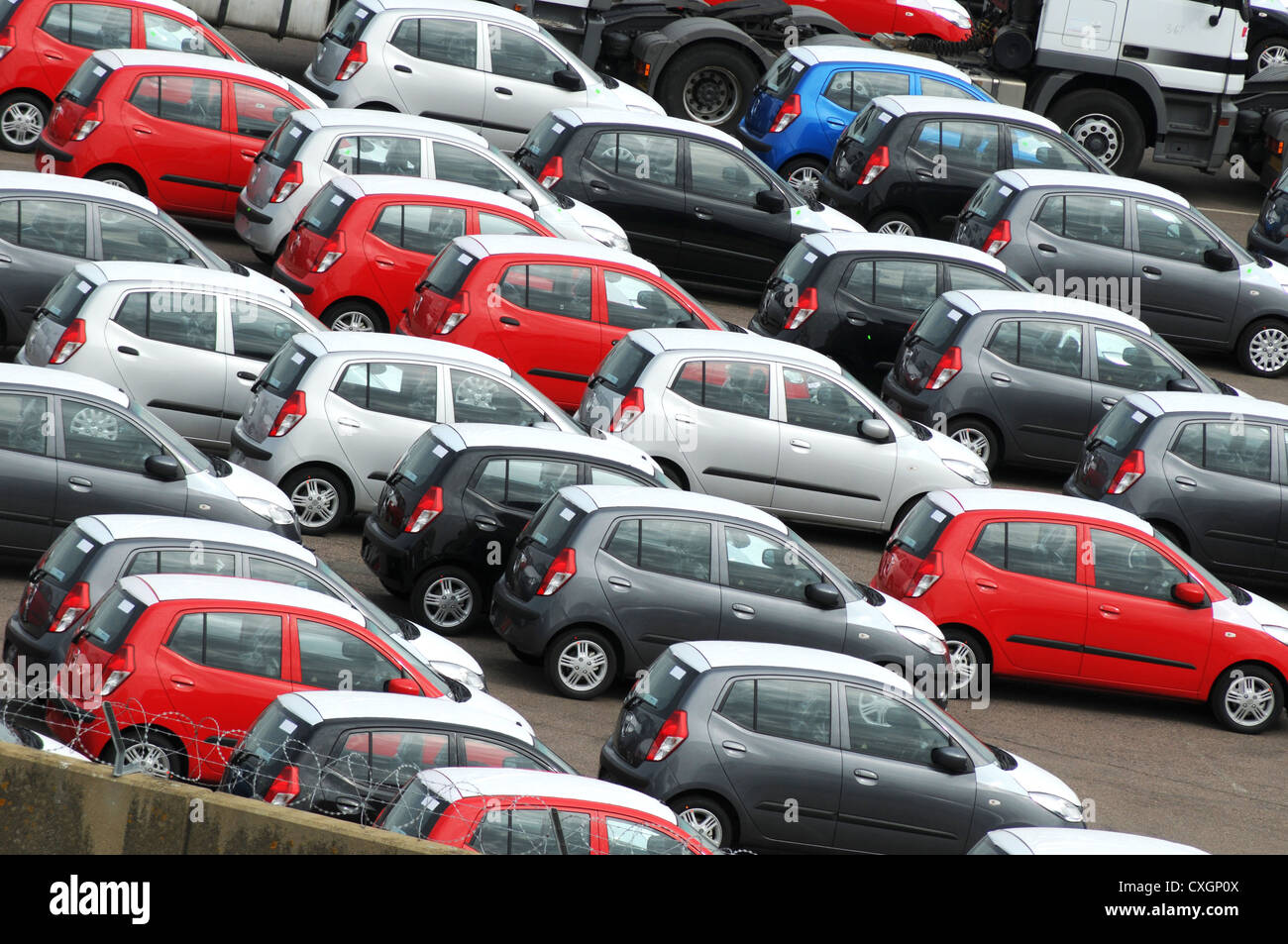 A car park of small cars delivered at a dock all multicoloured Stock ...