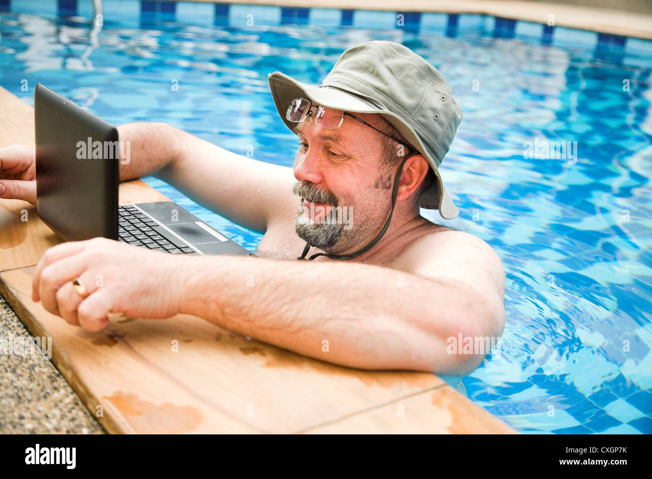 man in pool with laptop Stock Photo - Alamy