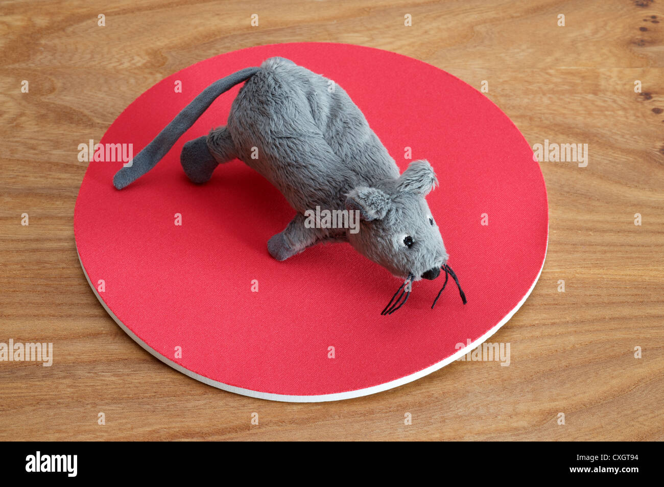 Fluffy toy mouse standing on a computer mousemat Stock Photo - Alamy