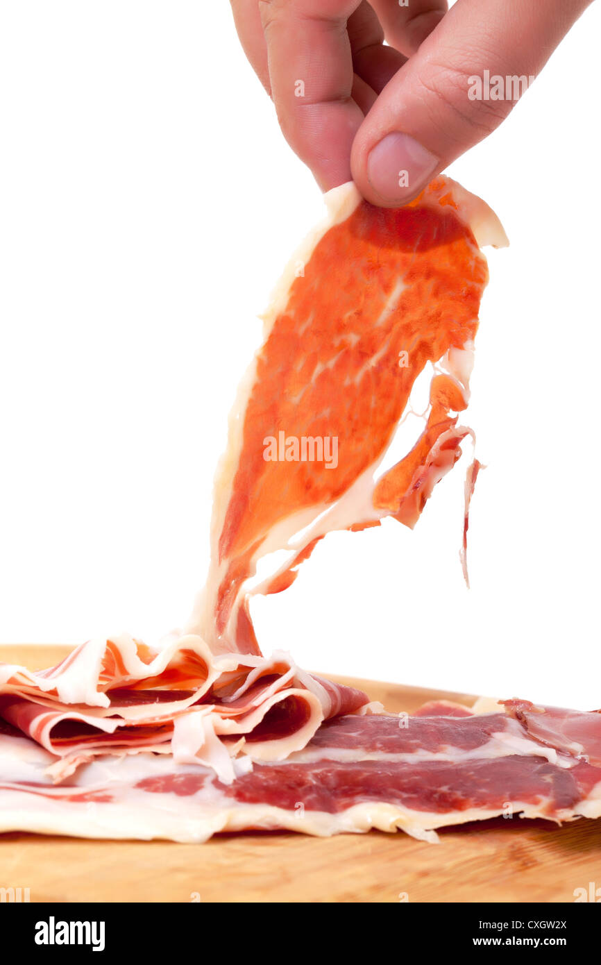 Thinly Sliced Spanish Jamon with a Hand, on a white background Stock ...