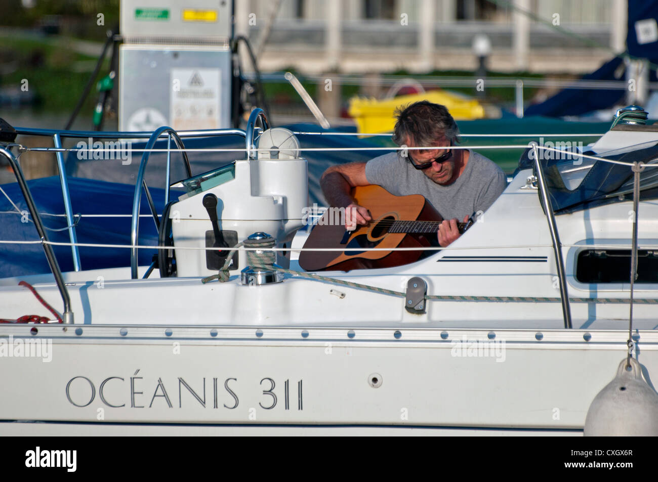 Guitarist on Boat strumming while he relaxes Stock Photo - Alamy