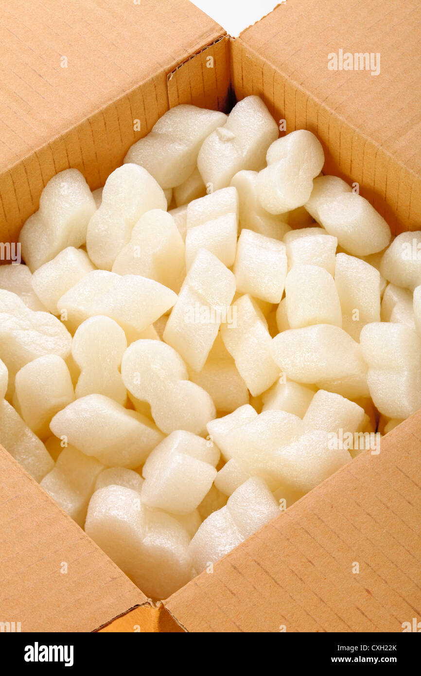 A cardboard box with yellow packing styrofoam peanuts Stock Photo - Alamy